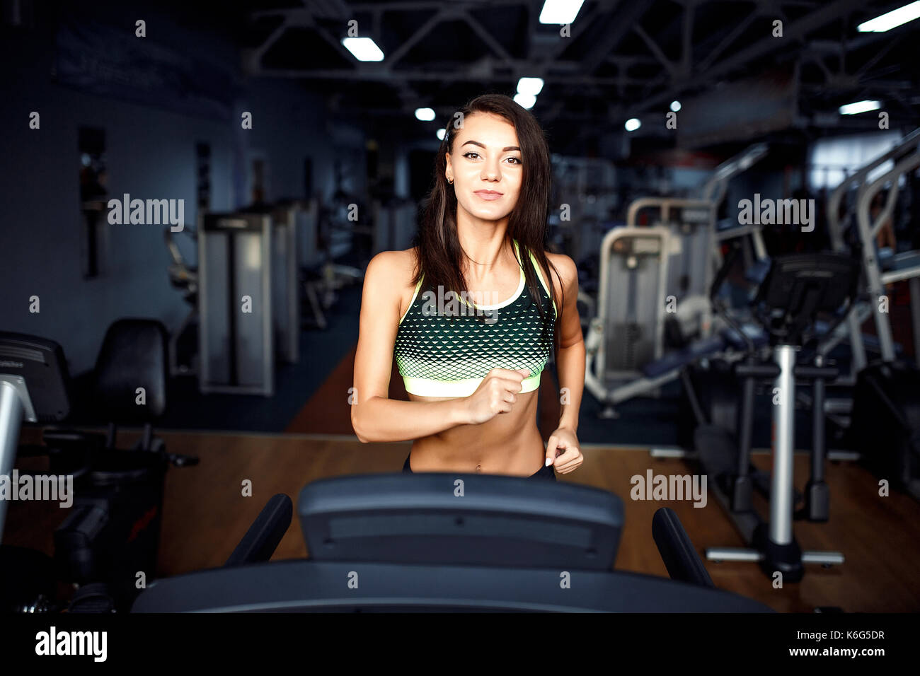 Young fitness woman doing cardio exercises at the gym running on a ...