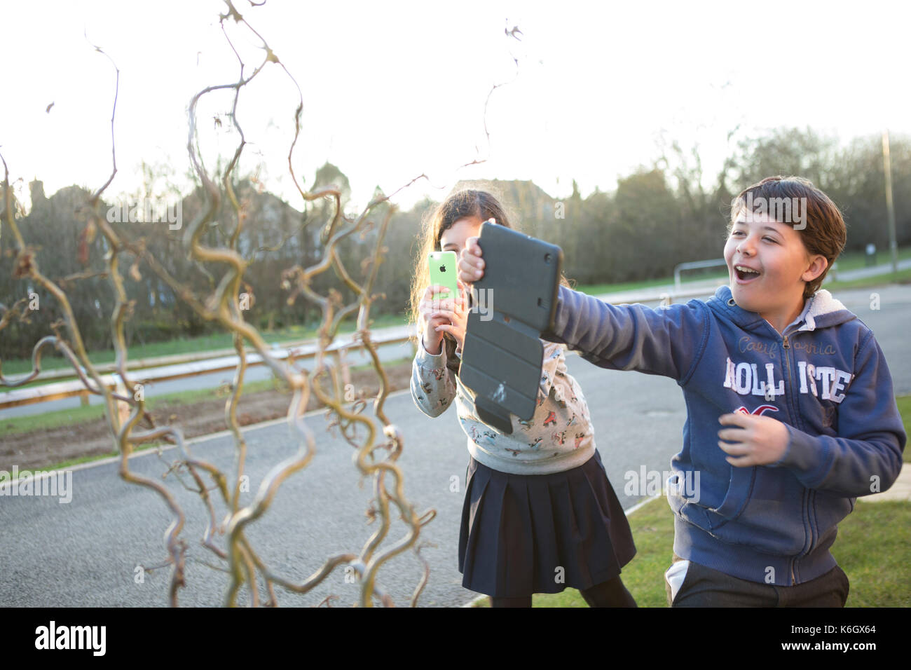 boy and girl using mobile phones to take pictures Stock Photo - Alamy