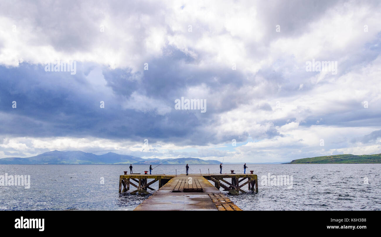 Five males fishing at the end of the abandoned pier at Portencross ...