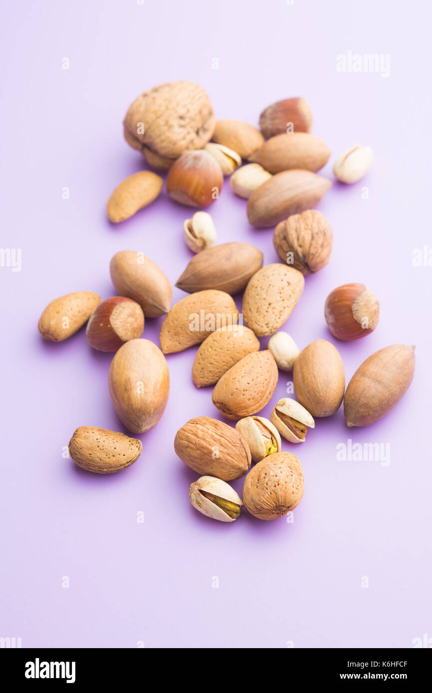 Different types of nuts in the nutshell on purple background Stock ...