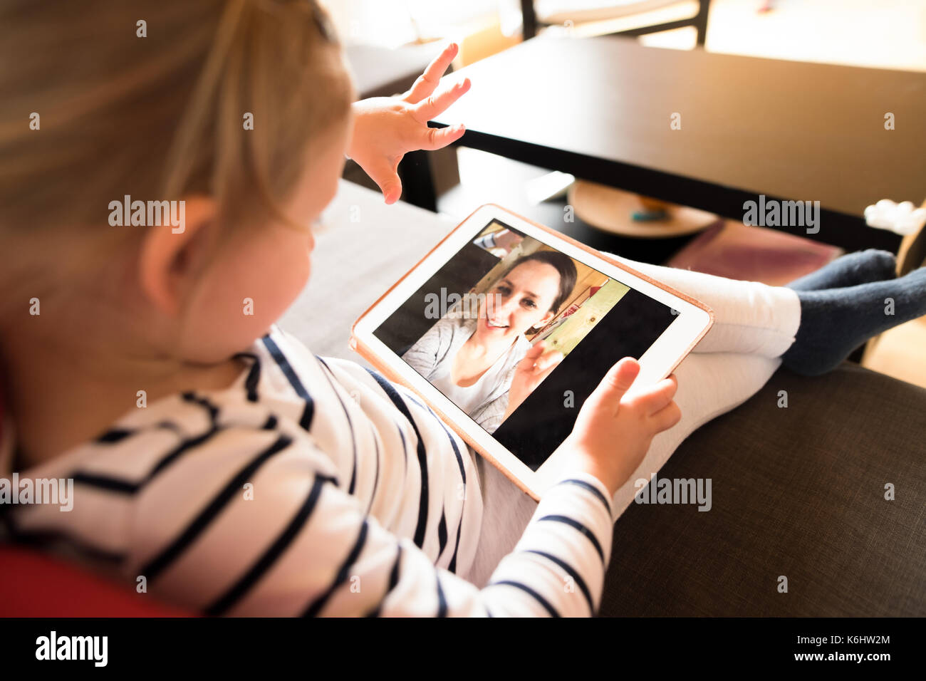 Little girl at home with tablet, video chatting with her mother Stock ...