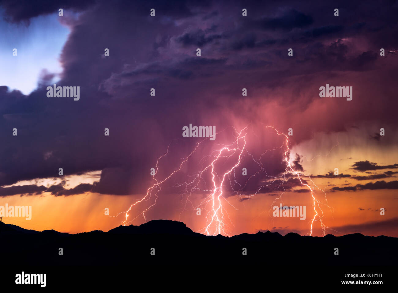 A series of powerful lightning bolts strike in a sunset storm near ...