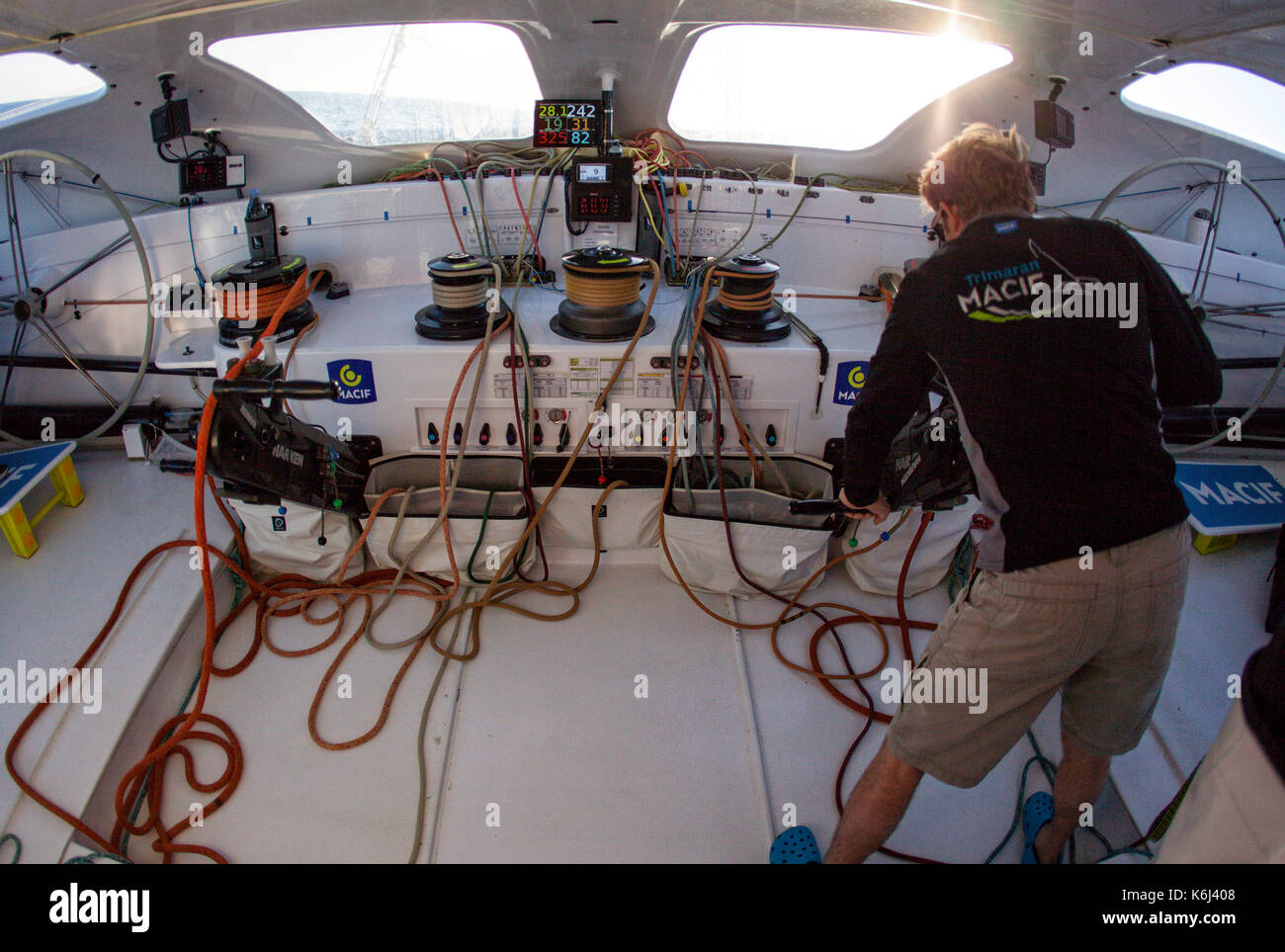 Sailor maneuvering trimaran in cockpit, Atlantic Ocean, Brittany ...