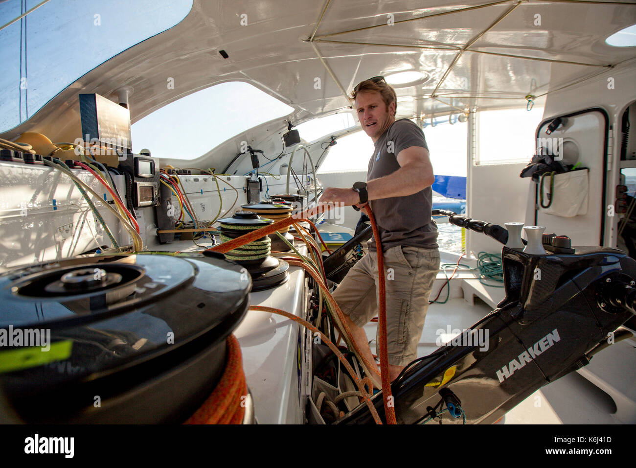 Sailor maneuvering trimaran in cockpit, Atlantic Ocean, Brittany ...
