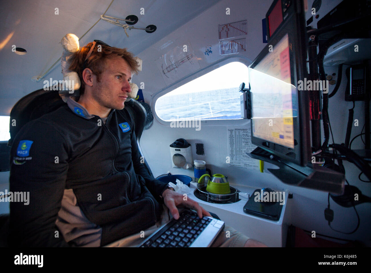 Sailor working on navigation inside life and navigation station onboard ...