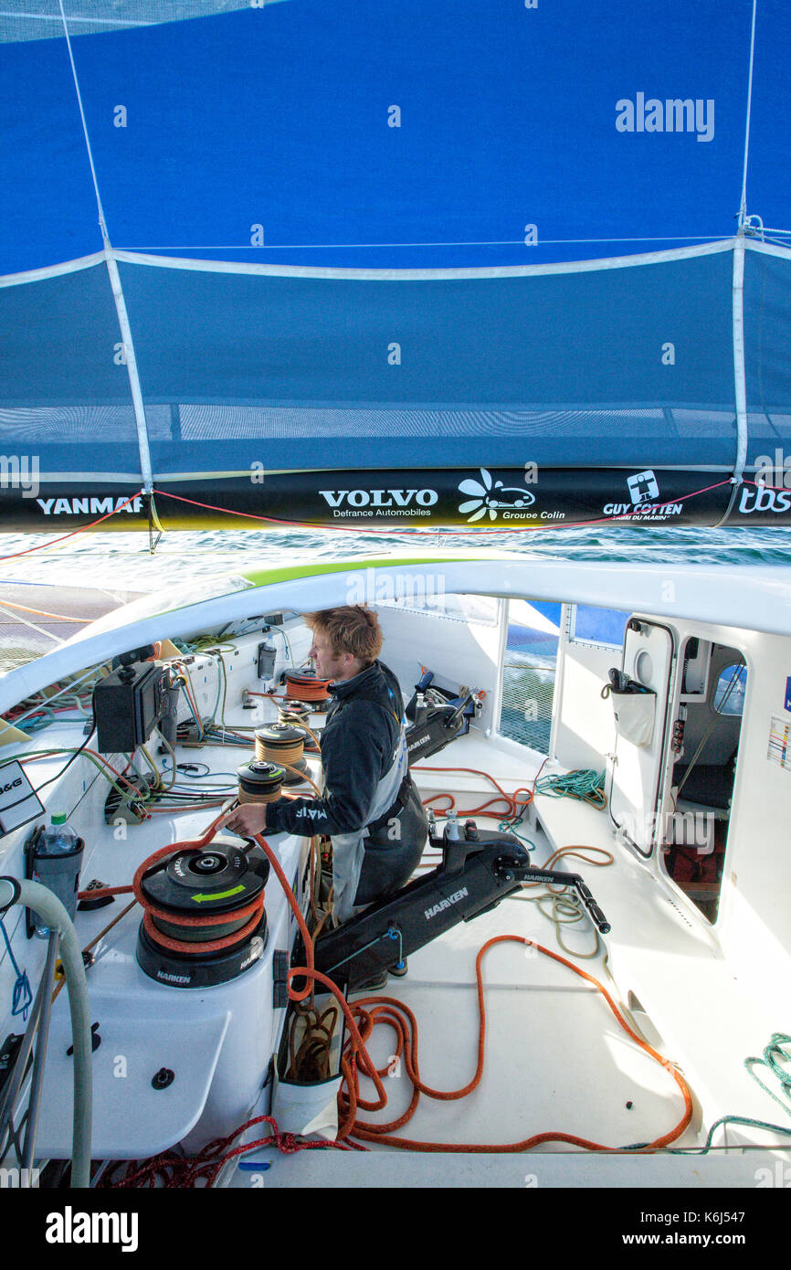 Sailor maneuvering trimaran from cockpit, Atlantic Ocean, Brittany ...