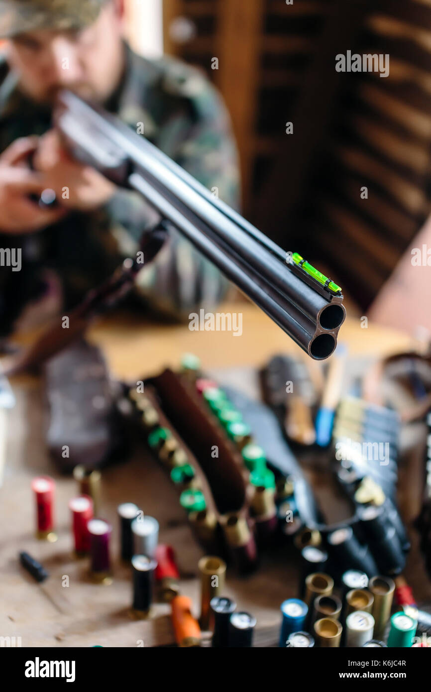 Front view of man checking shotgun sight while preparing for hunting ...