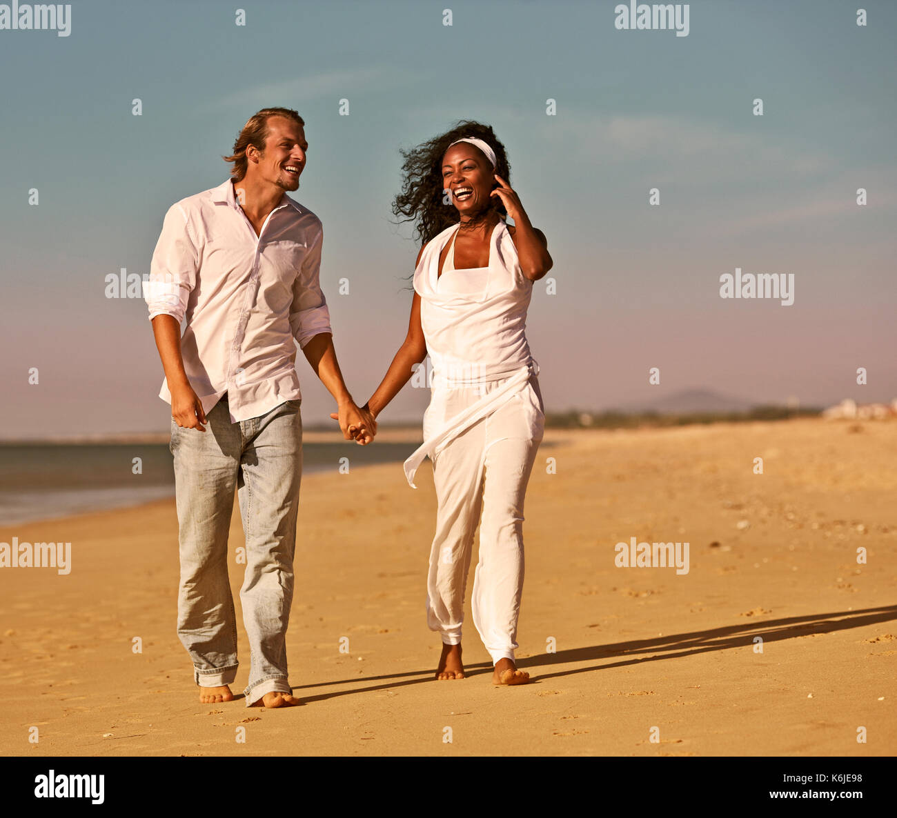Diversity Couple walking and running on beach Stock Photo - Alamy