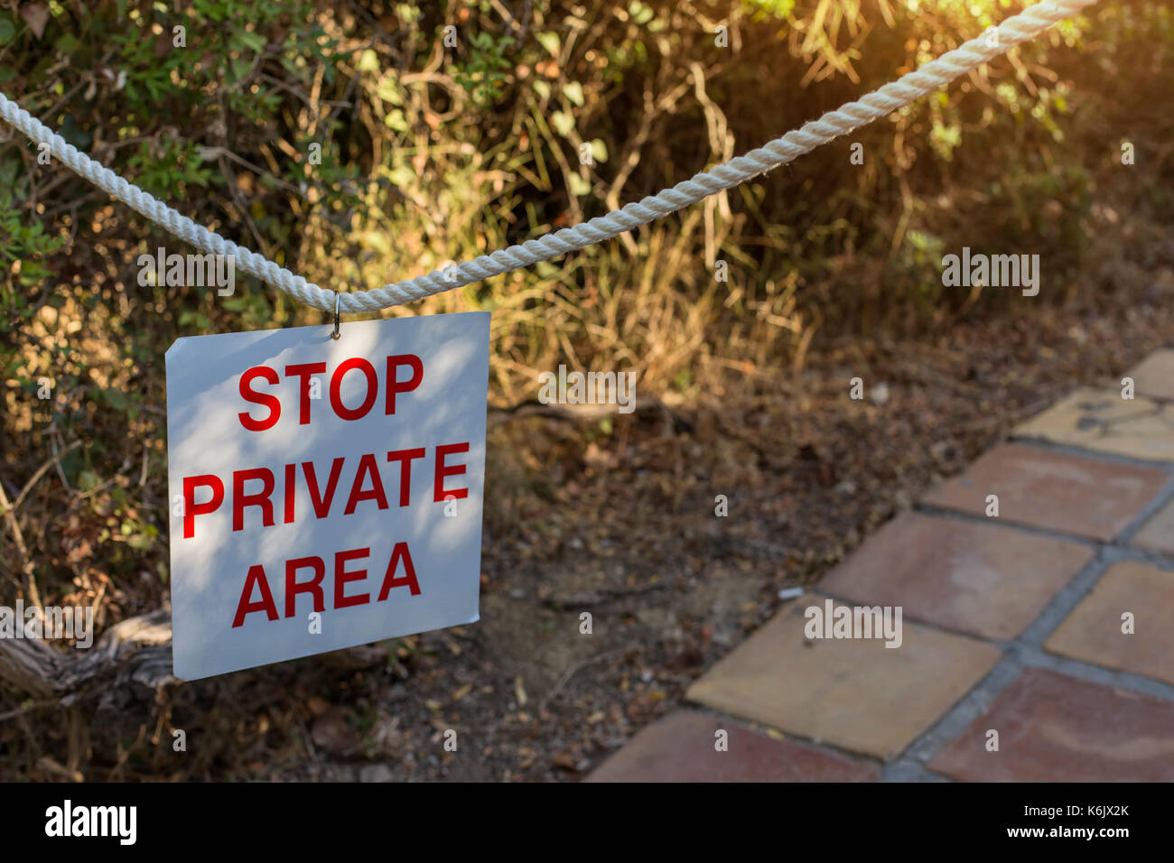 Sign says STOP Private AREA hanging on the rope Stock Photo - Alamy