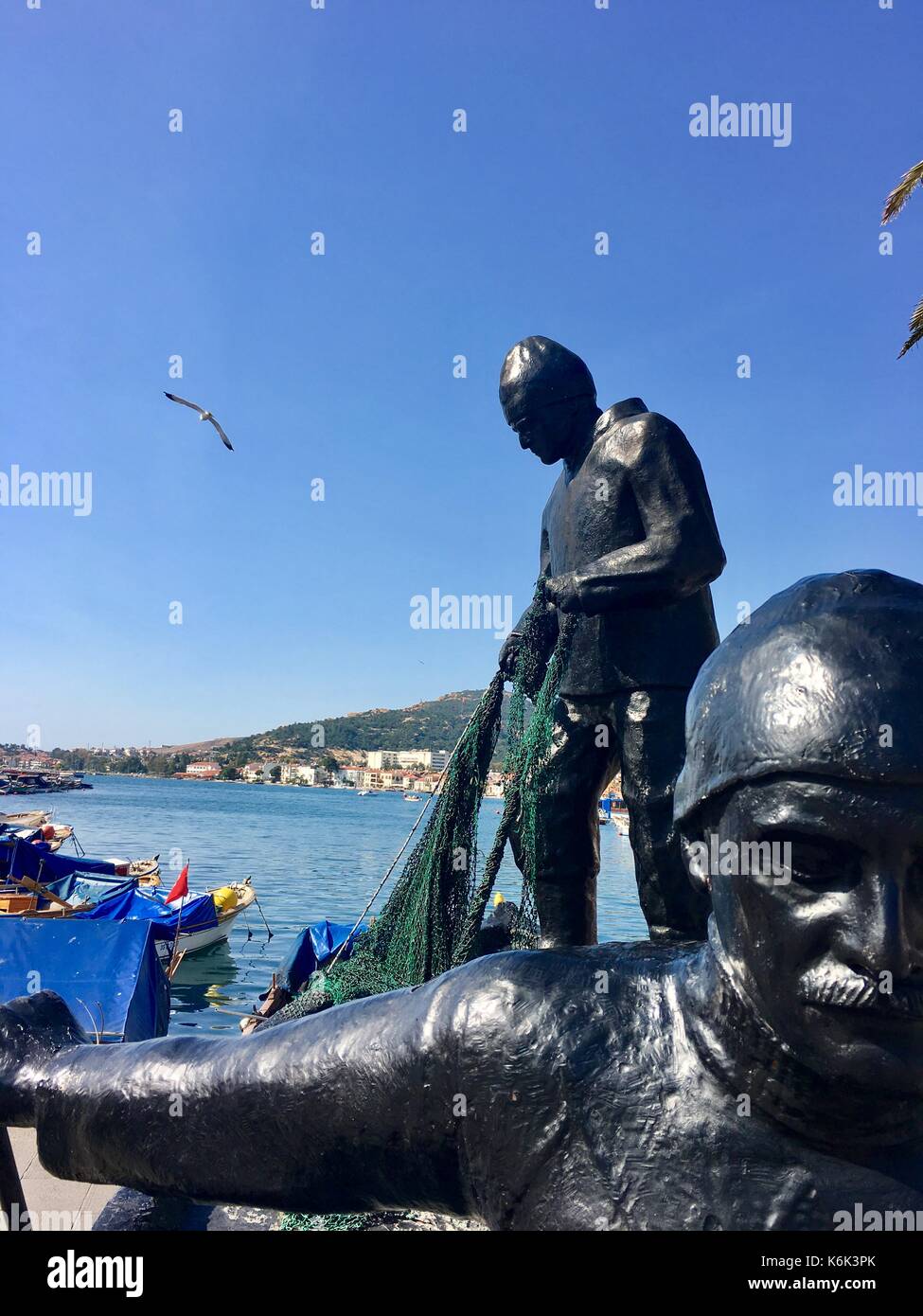 Fisherman sculpture at the middle of old Foca Harbor Izmir. The town ...