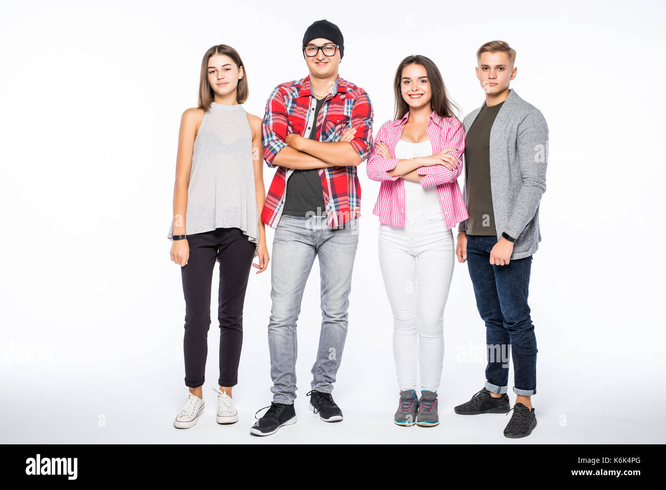 Full length of causal young four friends posing in front of camera ...