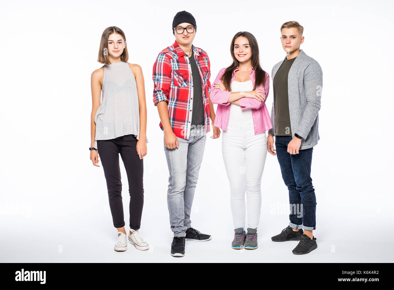 Full length of causal young four friends posing in front of camera ...