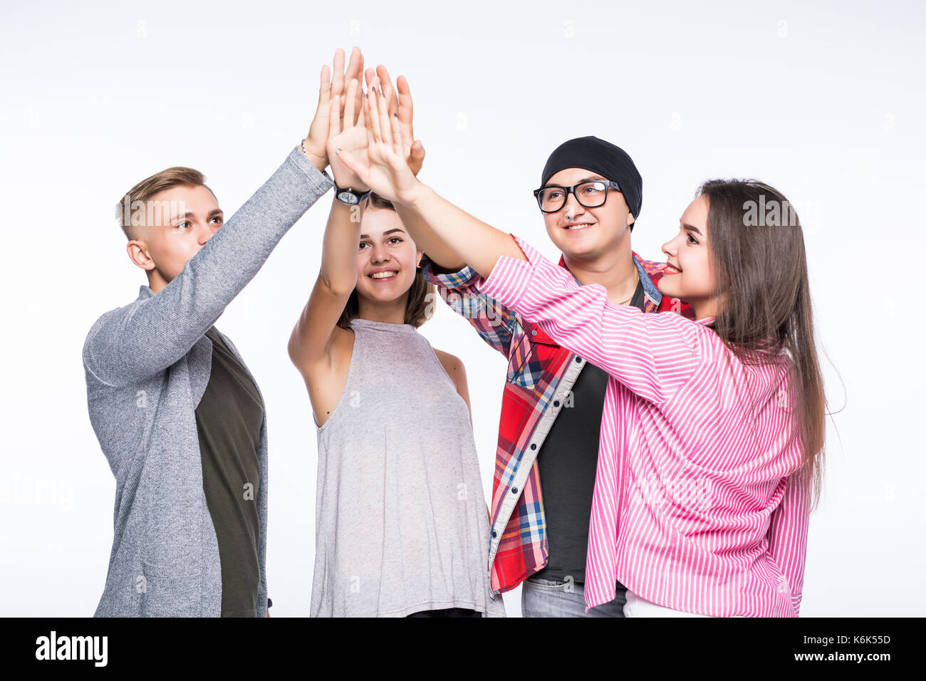 Happy group of young friends giving a high-five isolated over a white ...