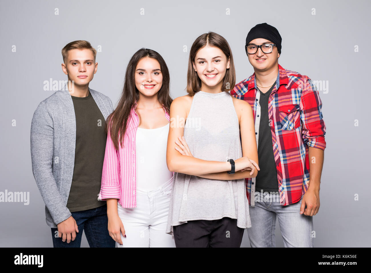 Happy smiling young group of friends standing together isolated on ...