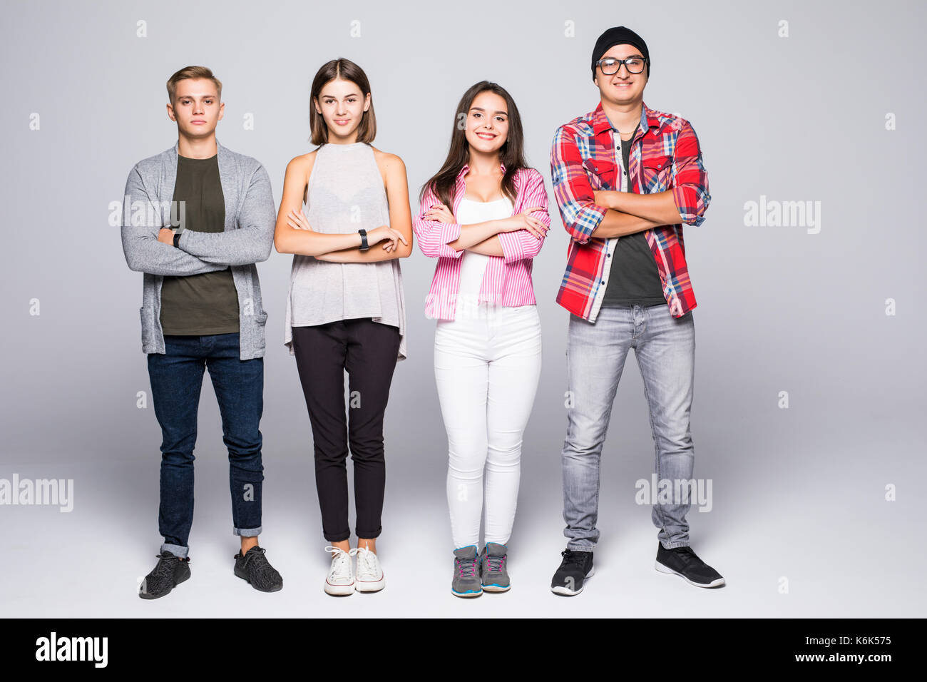 Happy smiling young group of friends standing together isolated on ...