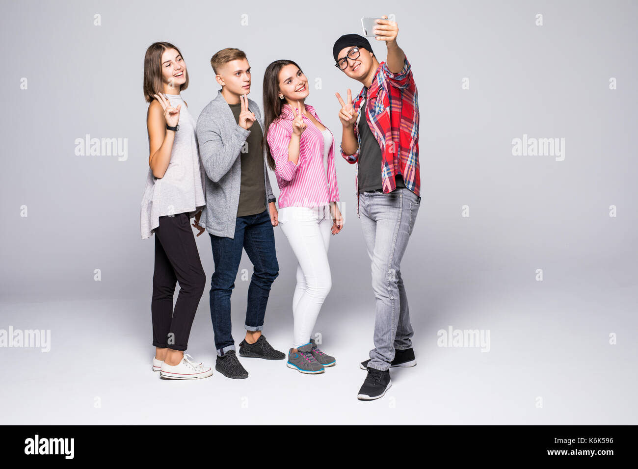 Four stylish young people on white background Stock Photo - Alamy