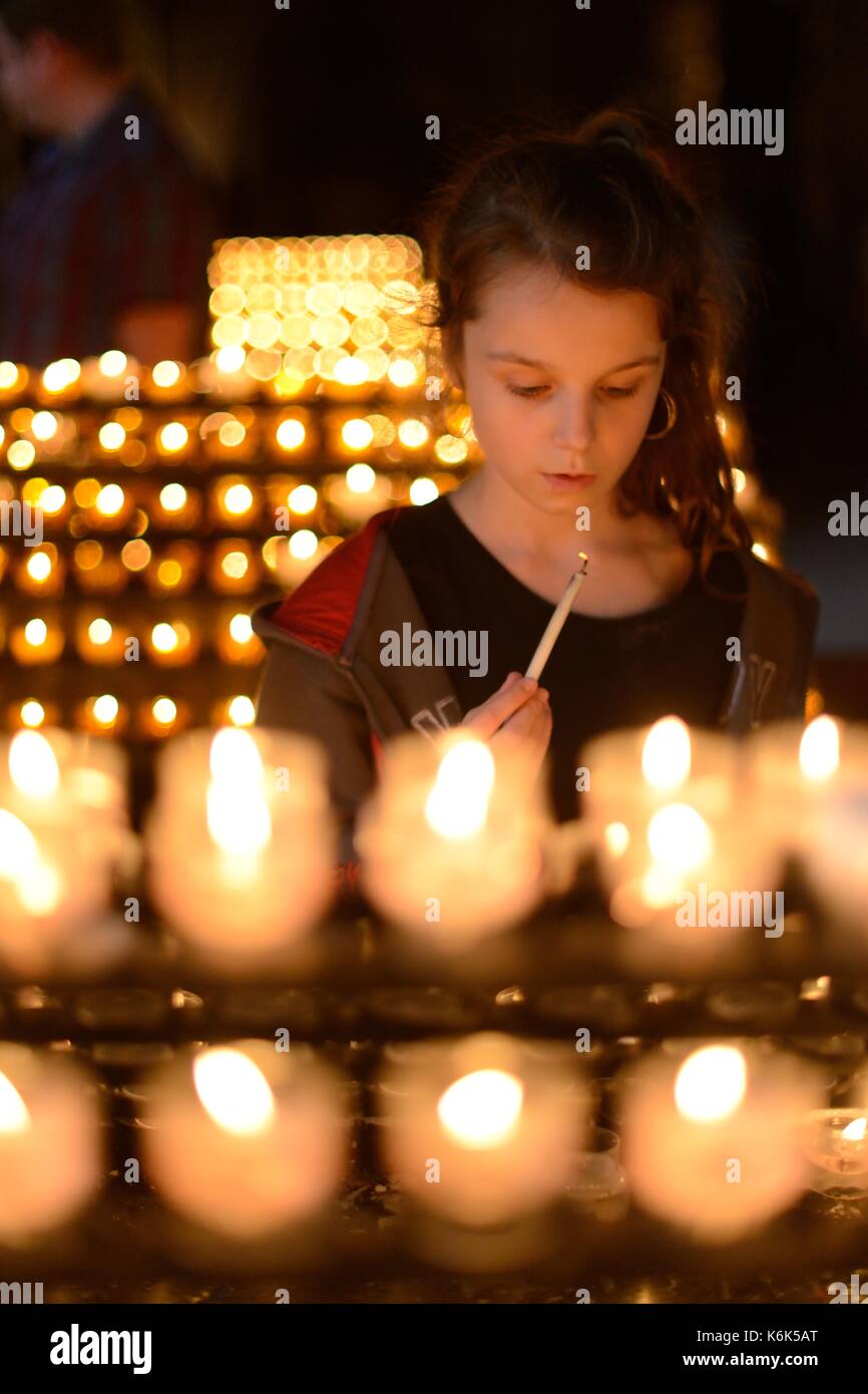 Youth lightning candle in church Stock Photo - Alamy