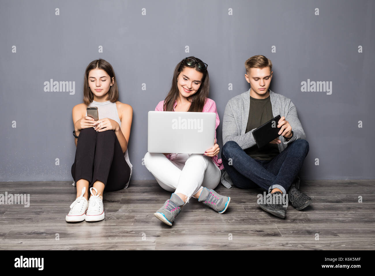 Diverse friends in coworking using smart devices, students preparing ...