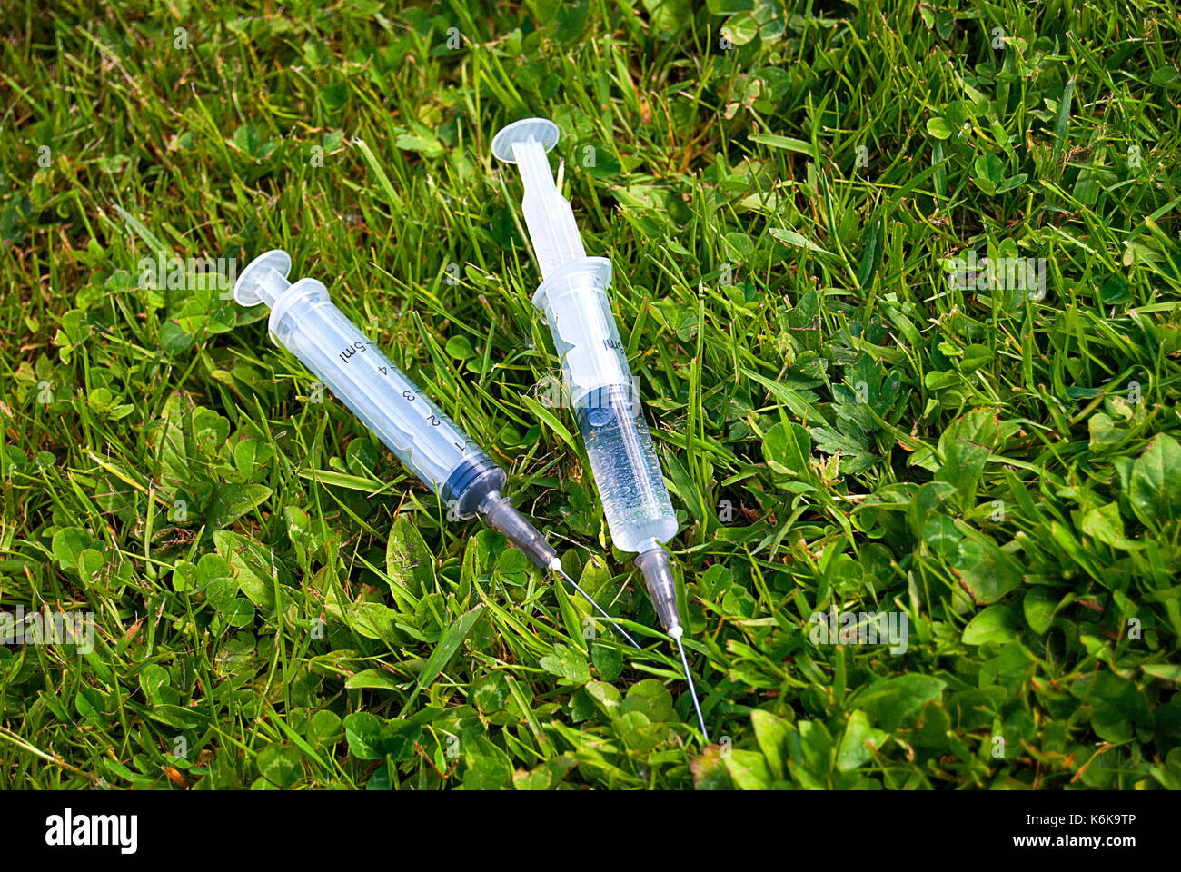 Syringe found in the grass Stock Photo - Alamy