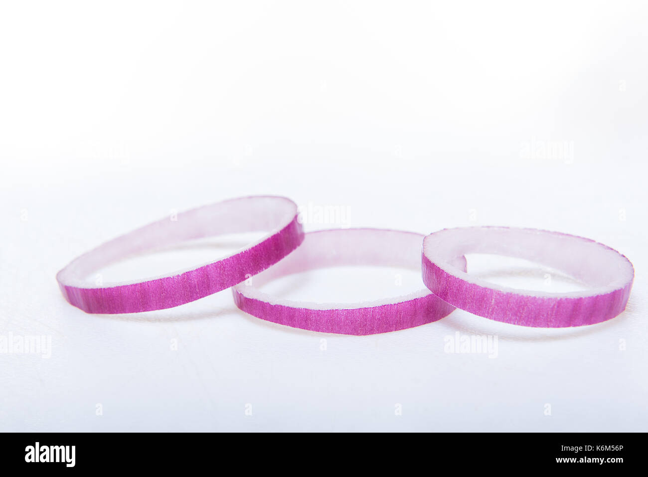 Three red onion rings on white background Stock Photo - Alamy