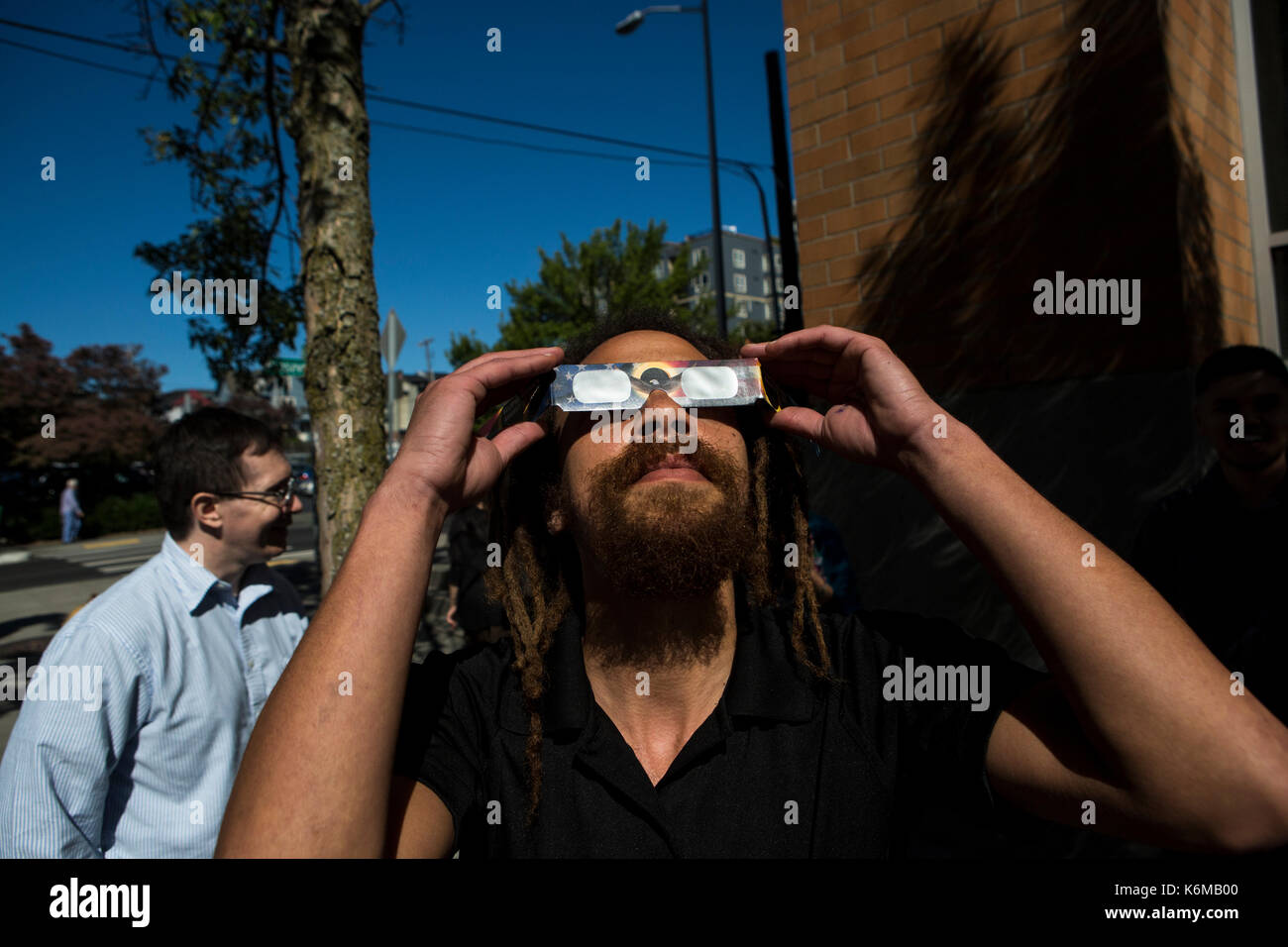 People gather on the streets of Seattle, WA, USA to watch the solar ...