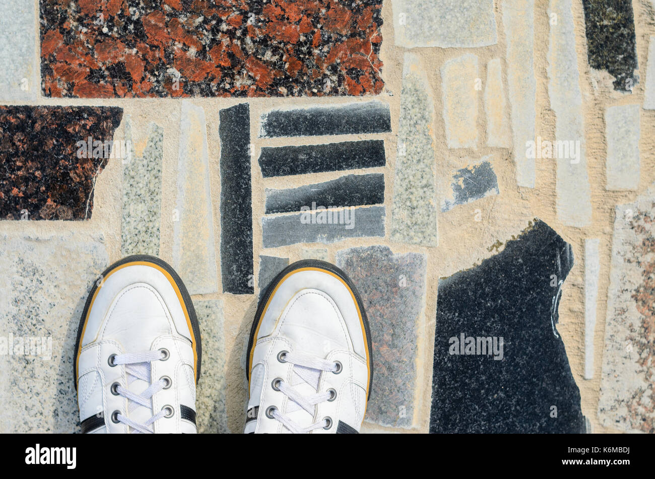 White Sneakers on a Multi-Material Mosaic Paving Stone Made of Granite ...