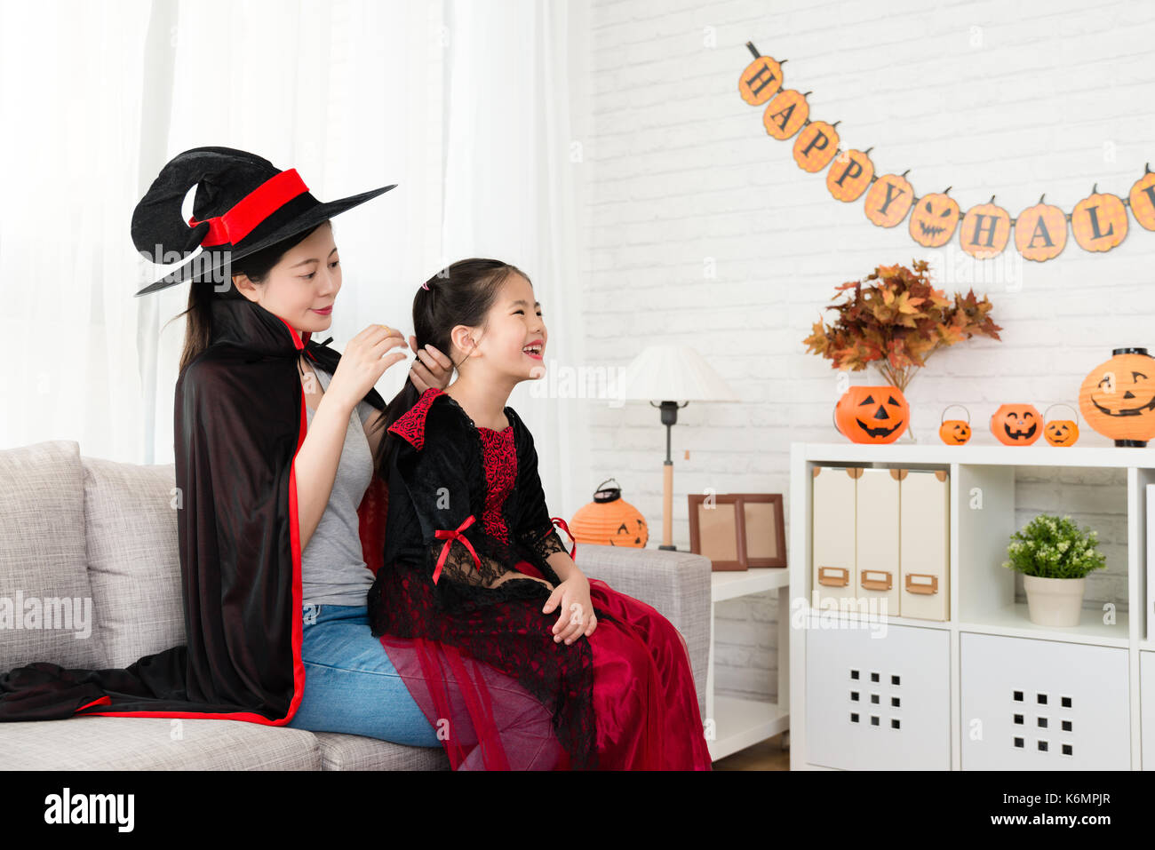 beautiful mother wearing vampire cloak to helping her happy daughter to ...