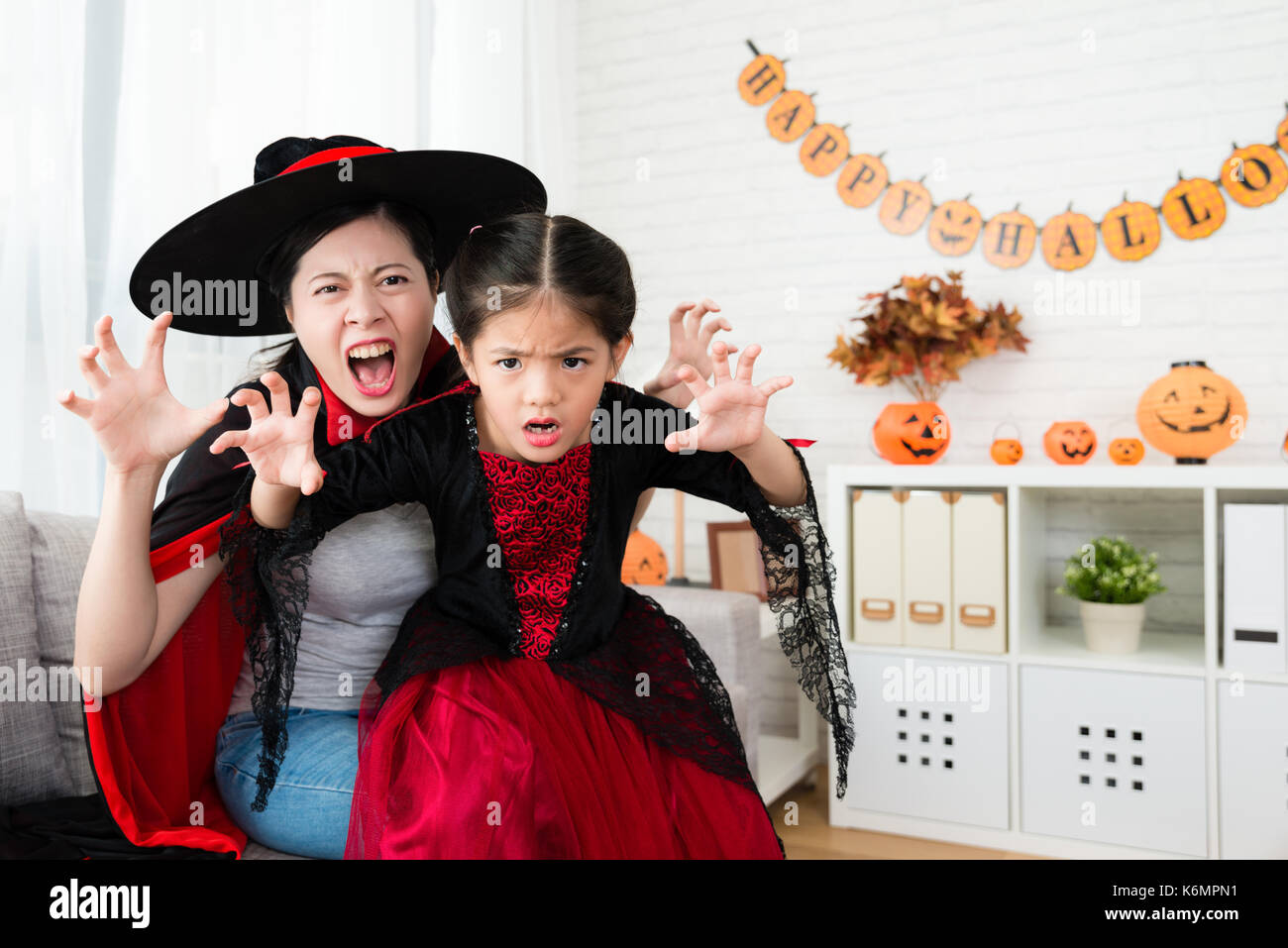 beautiful mother wearing vampire witch cloak and her cute girl use ...