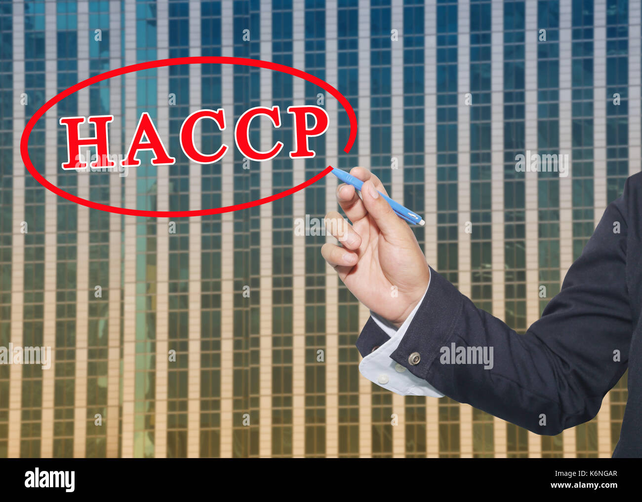 hand of a business man use a pen write text system HACCP on glass wall ...