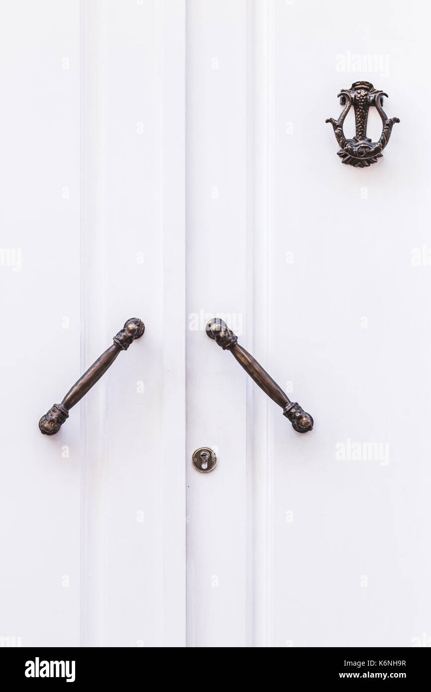 White door with beautiful carved metal handles and lock Stock Photo - Alamy