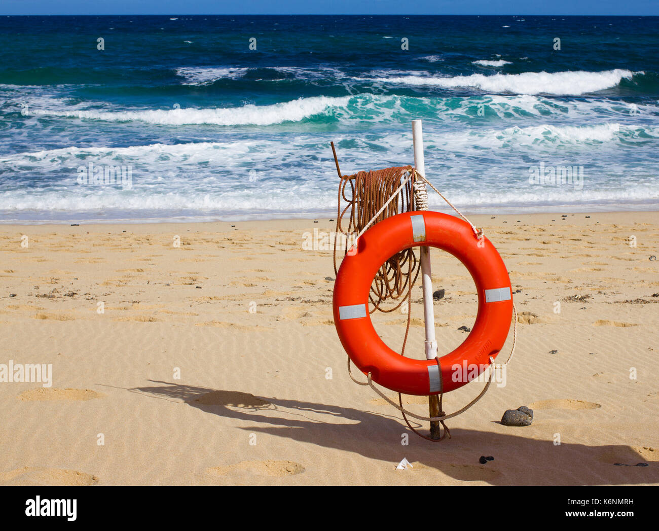 Swimming circle. Life buoy red color on beach with bright sand and sky ...