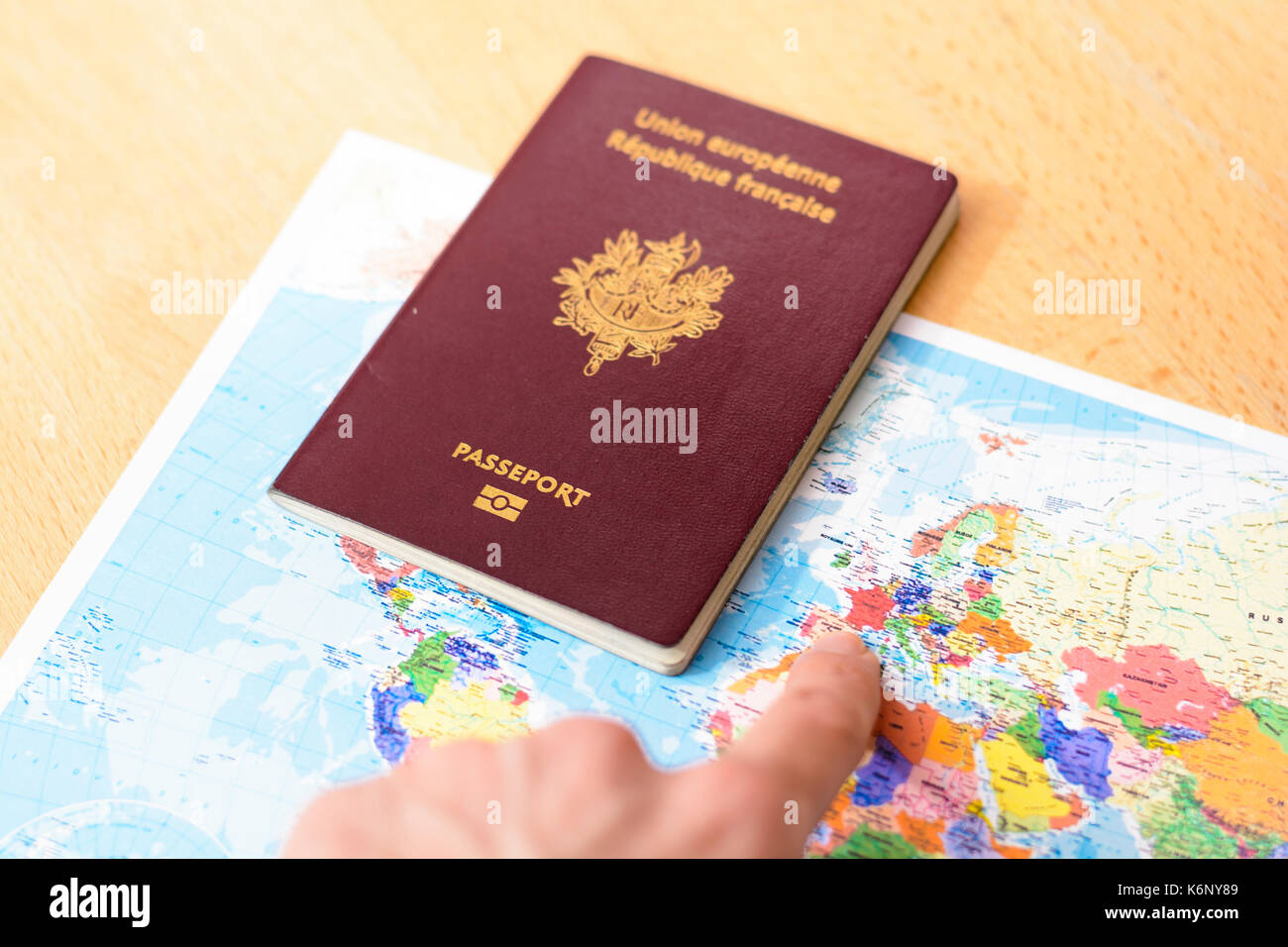Passport and hand with finger that show countries Stock Photo - Alamy