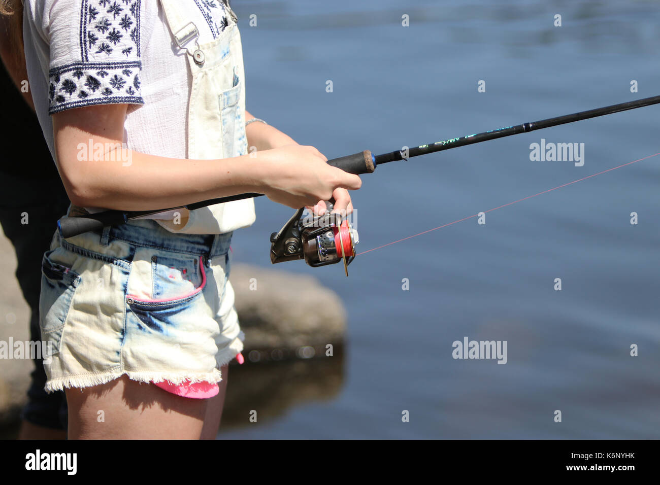 Woman with freckles and hot pants while fishing Stock Photo - Alamy