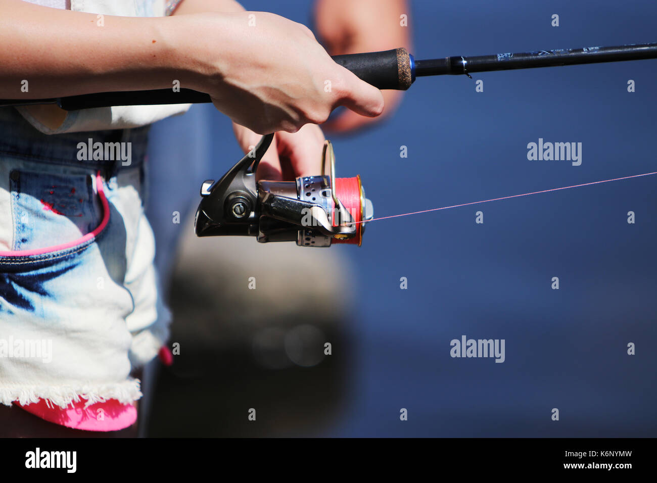 Woman with freckles and hot pants while fishing Stock Photo - Alamy