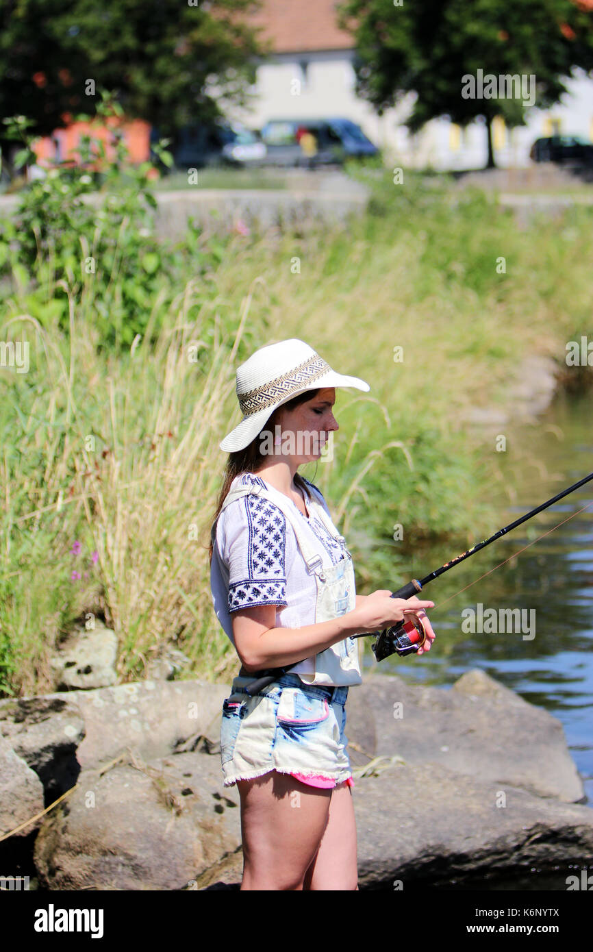 Woman with freckles and hot pants while fishing Stock Photo - Alamy