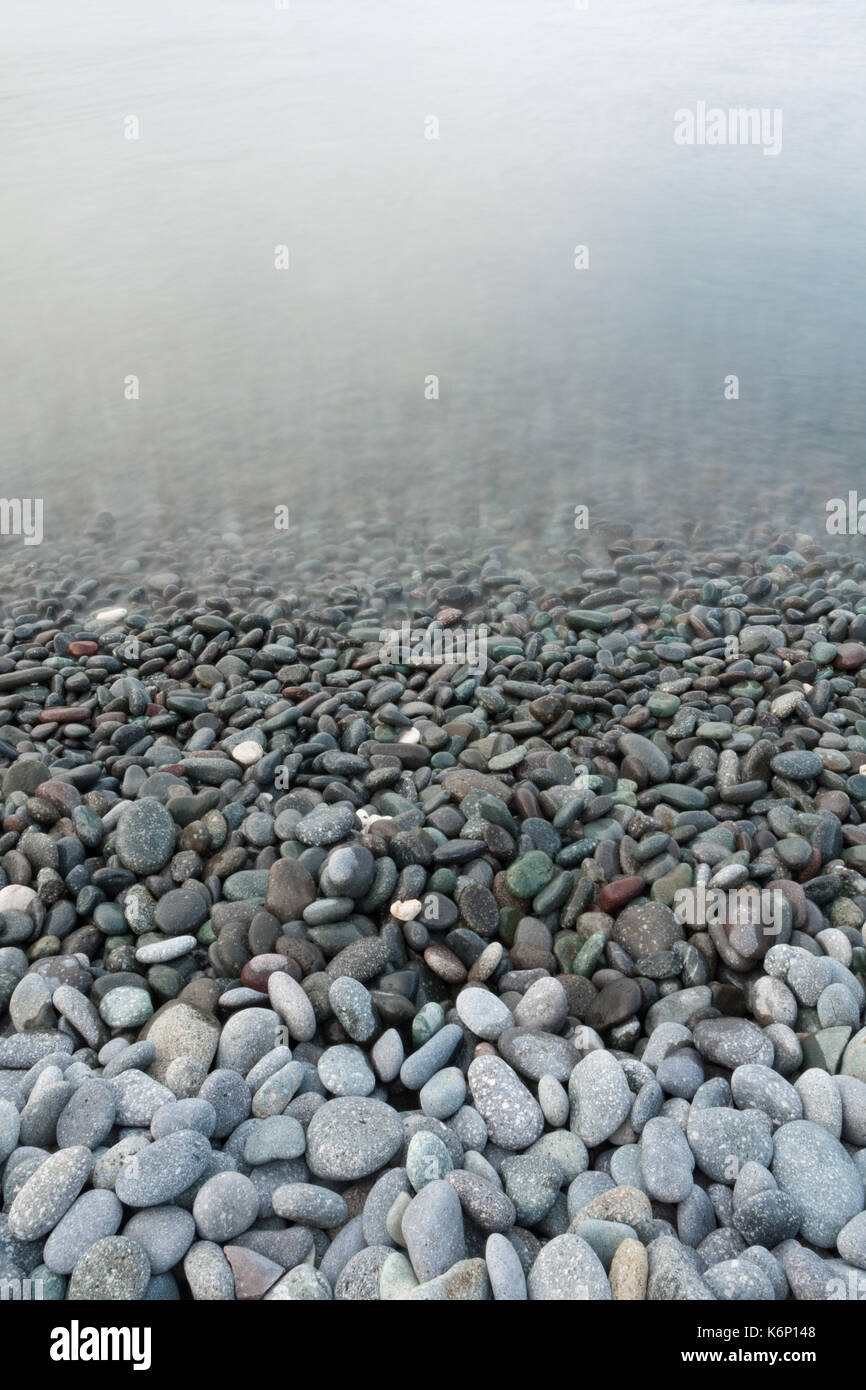 Pebbles washed by waves on a shingle beach, rocky seaside area ...