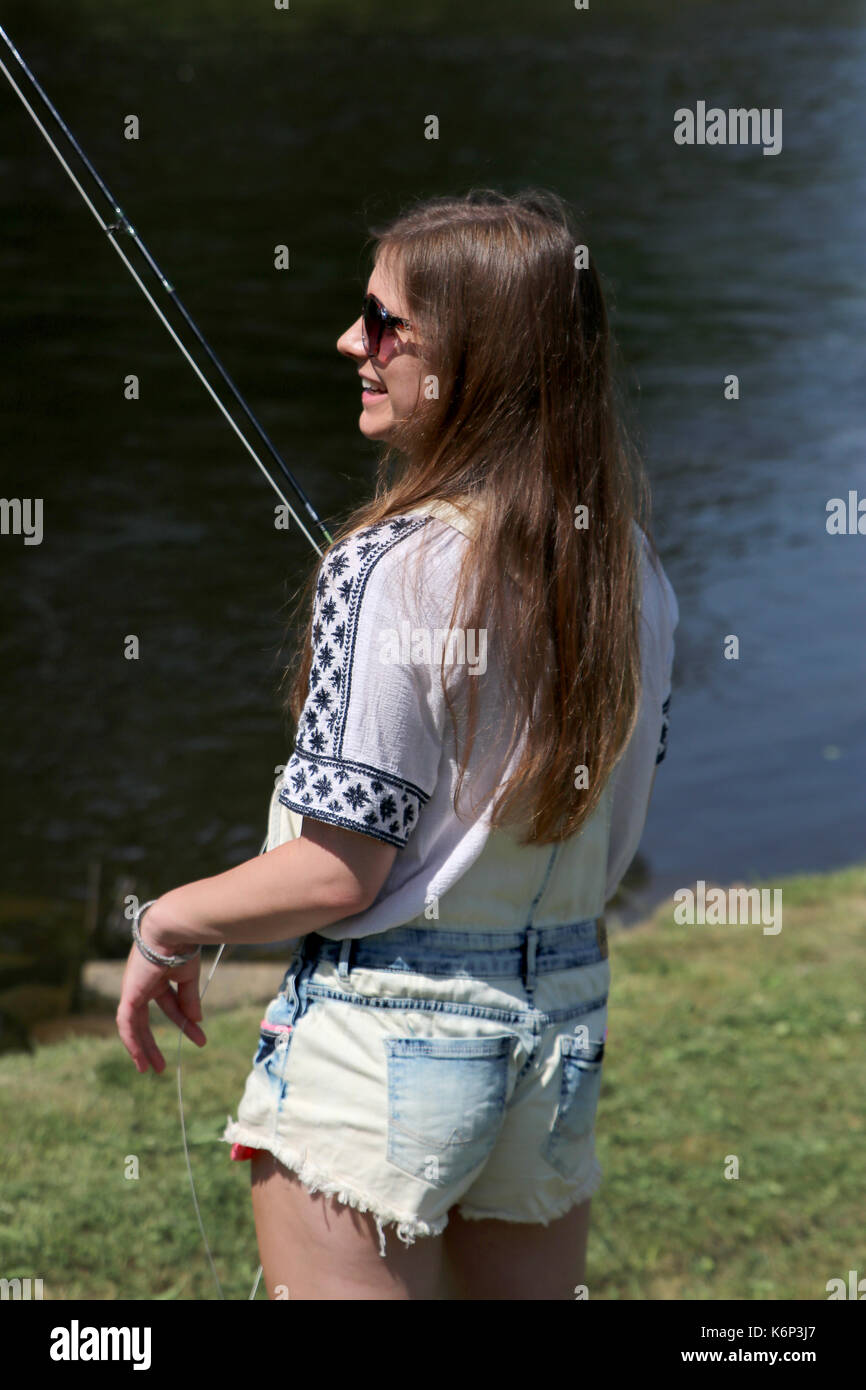 Woman with freckles and hot pants while fishing Stock Photo - Alamy
