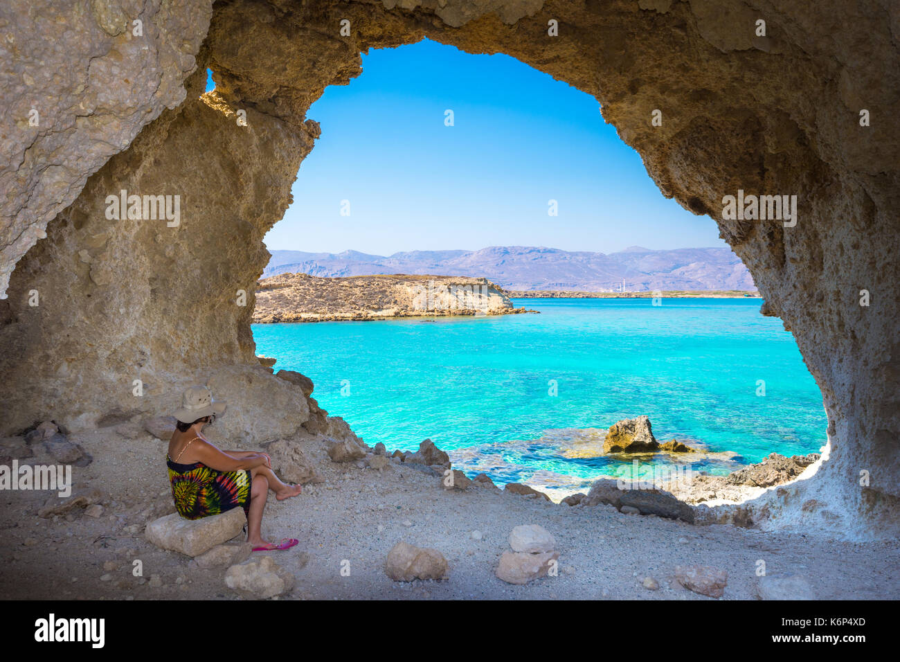 Amazing summer view of woman in a cave at Koufonisi island with magical ...
