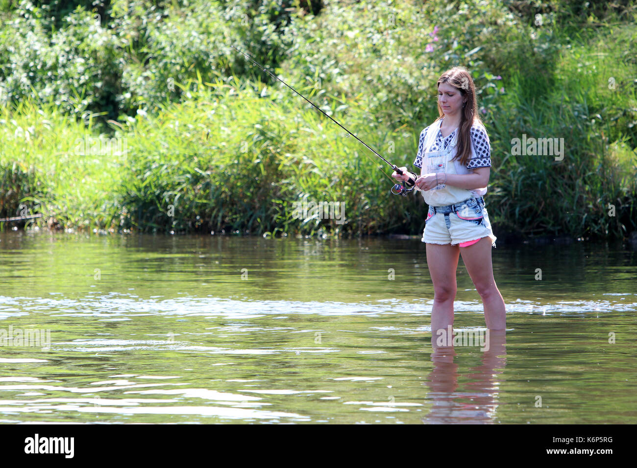 Woman with freckles and hot pants while fishing Stock Photo - Alamy
