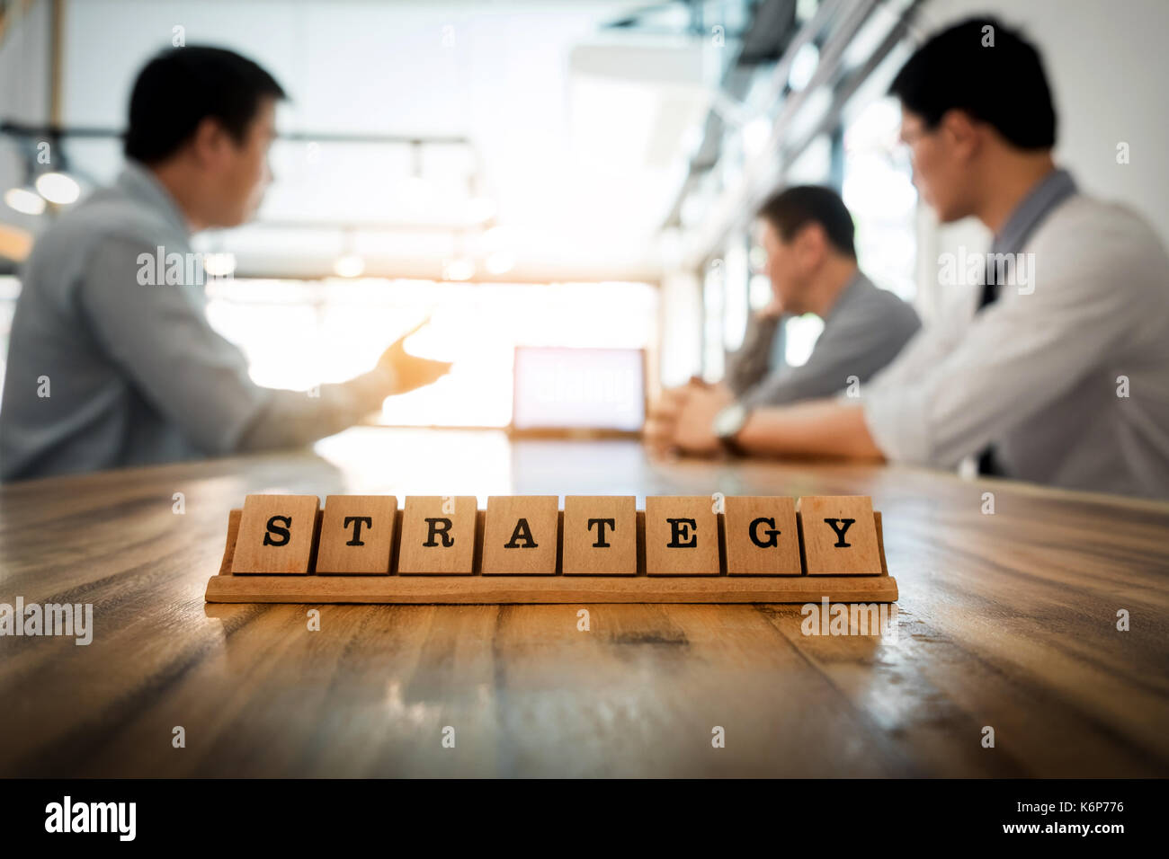 Strategy word on wood table with Business team work discussion together ...