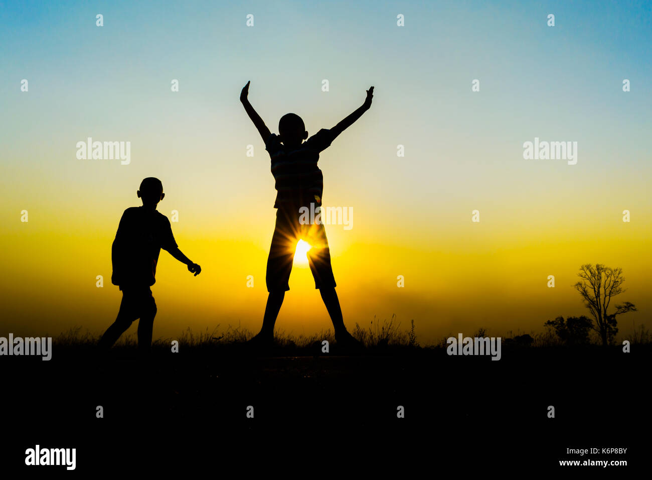 Silhouette of children jumping on sunset background Stock Photo - Alamy