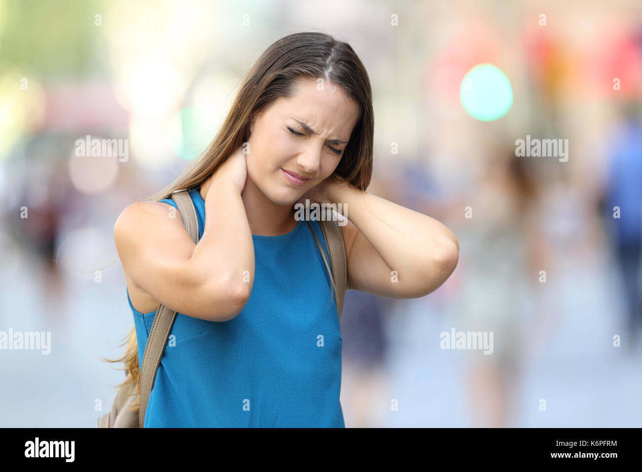 Single woman suffering neck ache walking on the street Stock Photo - Alamy