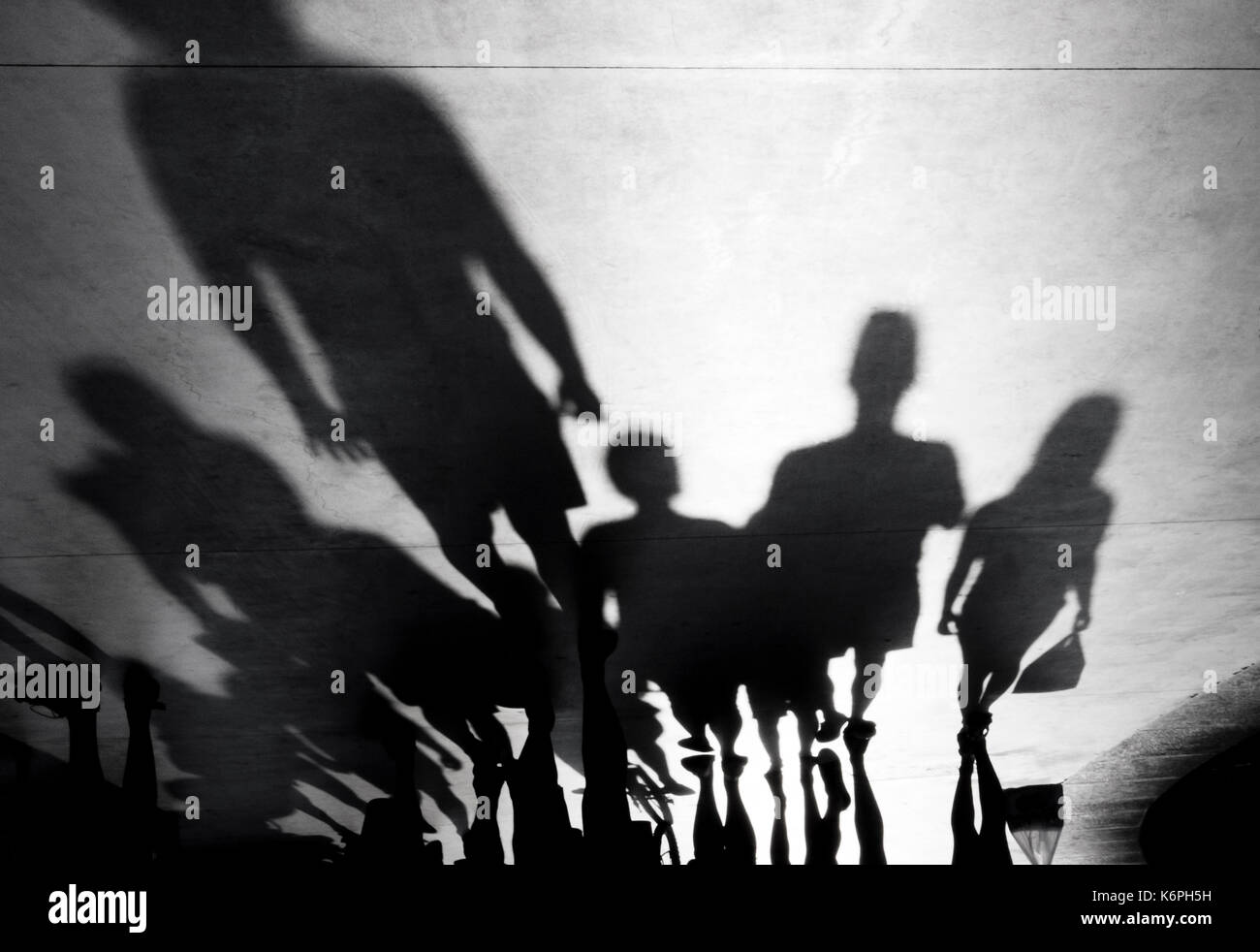 Blurry shadows silhouette of people walking towards the camera on black ...
