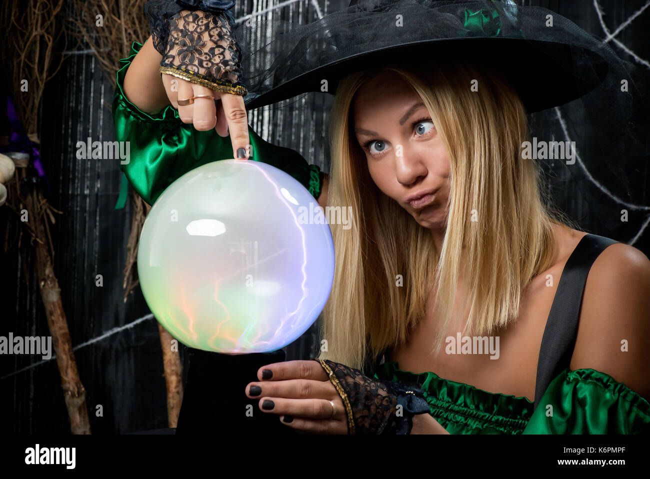Beautiful young witch posing with magic ball Stock Photo - Alamy