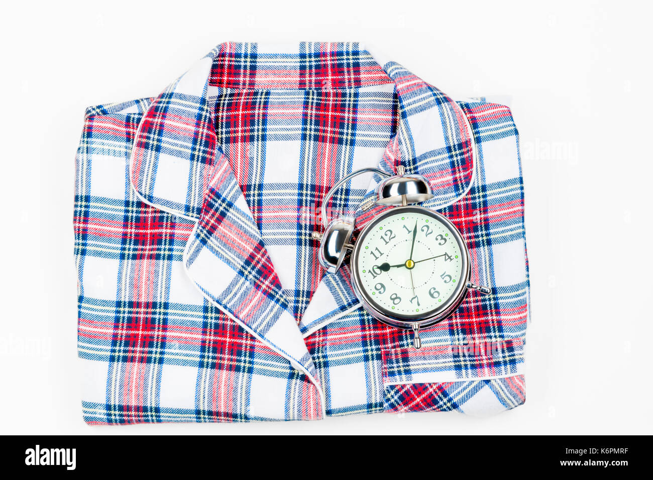 Classic pajama shirt and alarm clock on white background Stock Photo ...
