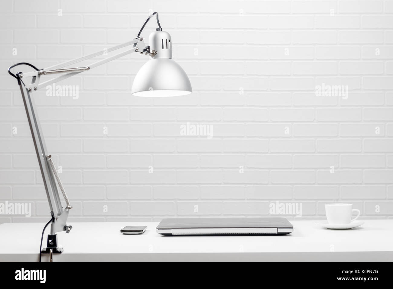 Empty workplace - white table and white brick wall Stock Photo - Alamy
