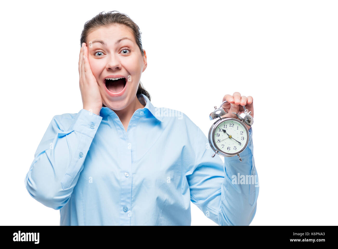 Emotional businesswoman with an alarm clock in shock on a white ...