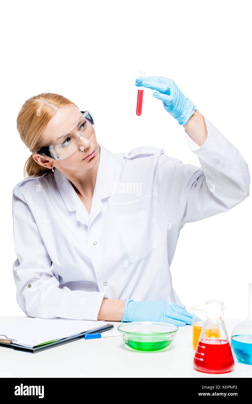 a concentrated laboratory assistant wearing glasses and gloves makes ...