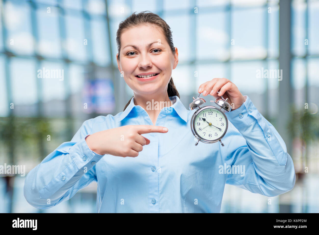 happy successful lady with an alarm clock in hand in office Stock Photo ...