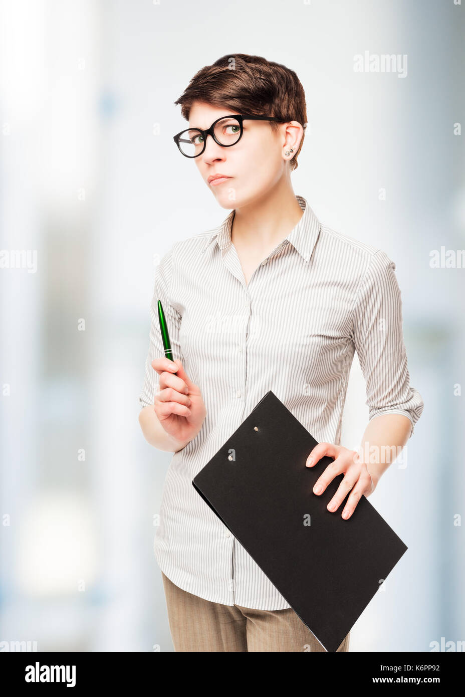 strict serious business woman with a folder in his hand posing in the ...